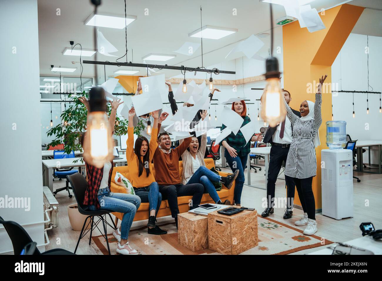 Group of business people throwing paper in air at modern startup office ...