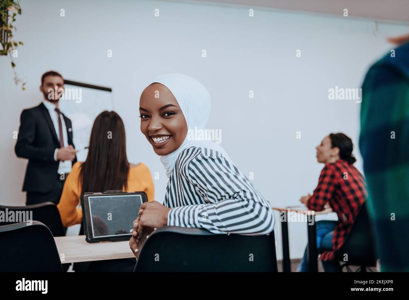 African American Muslim woman listens to a lecture aimed at business ...