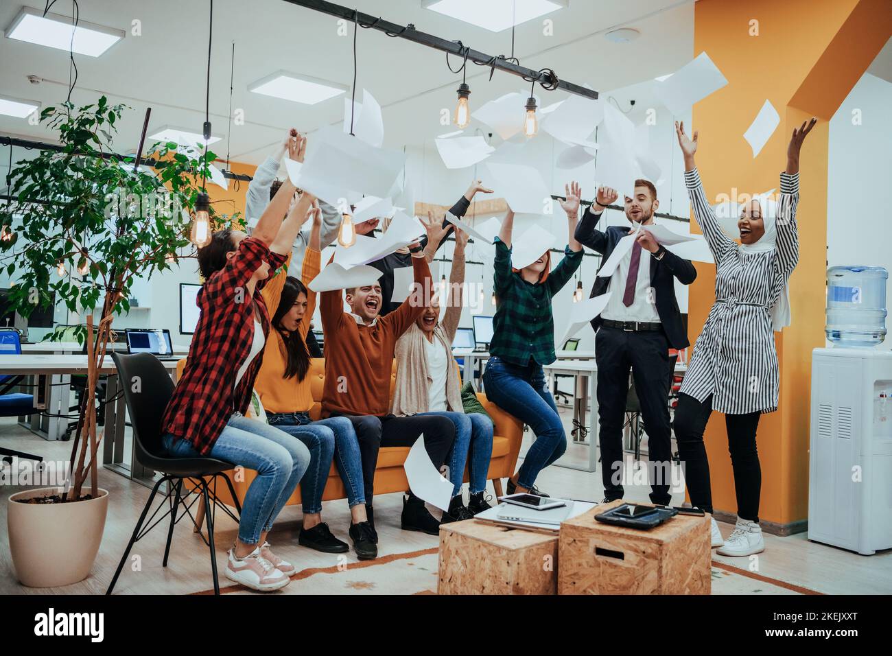 Group of business people throwing paper in air at modern startup office ...