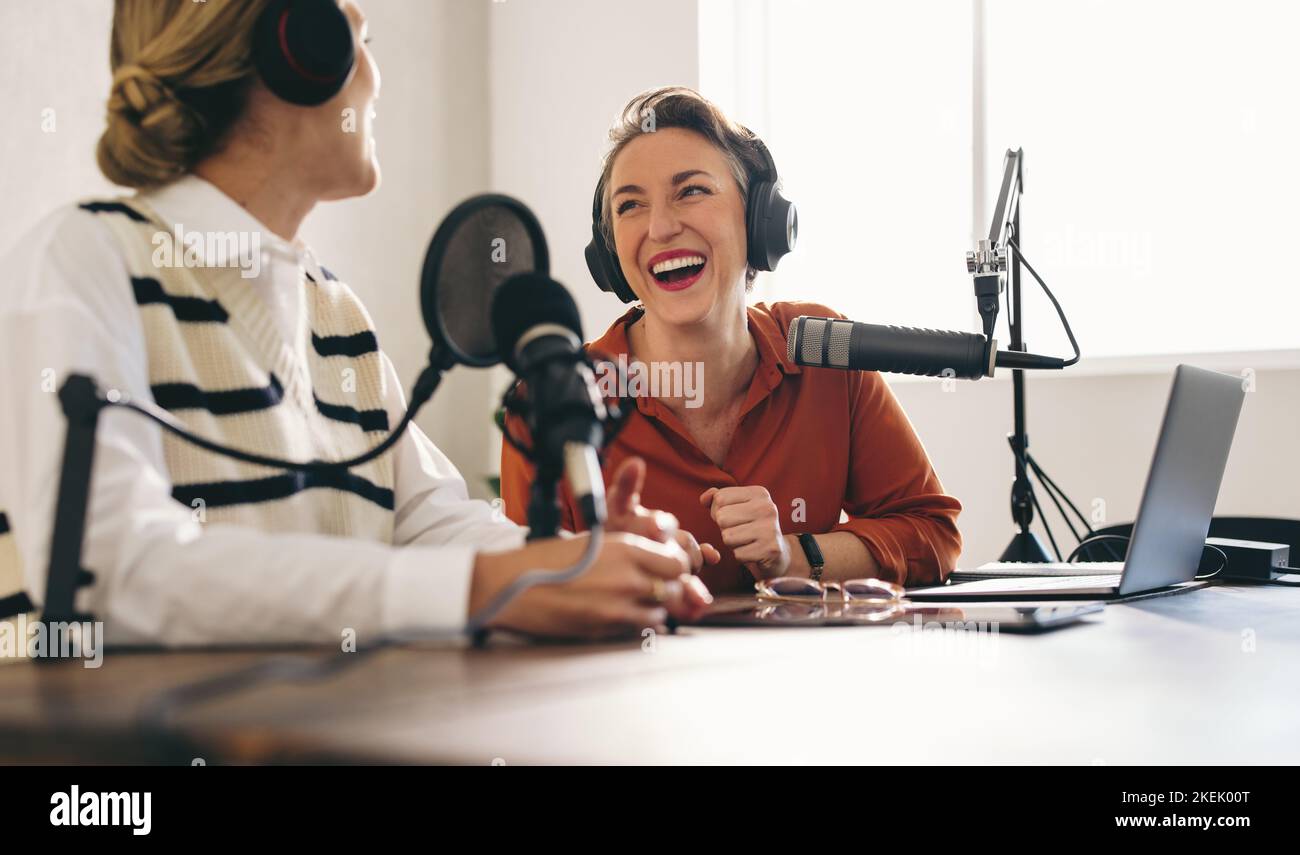 Female podcasters laughing and having a great time on an audio ...