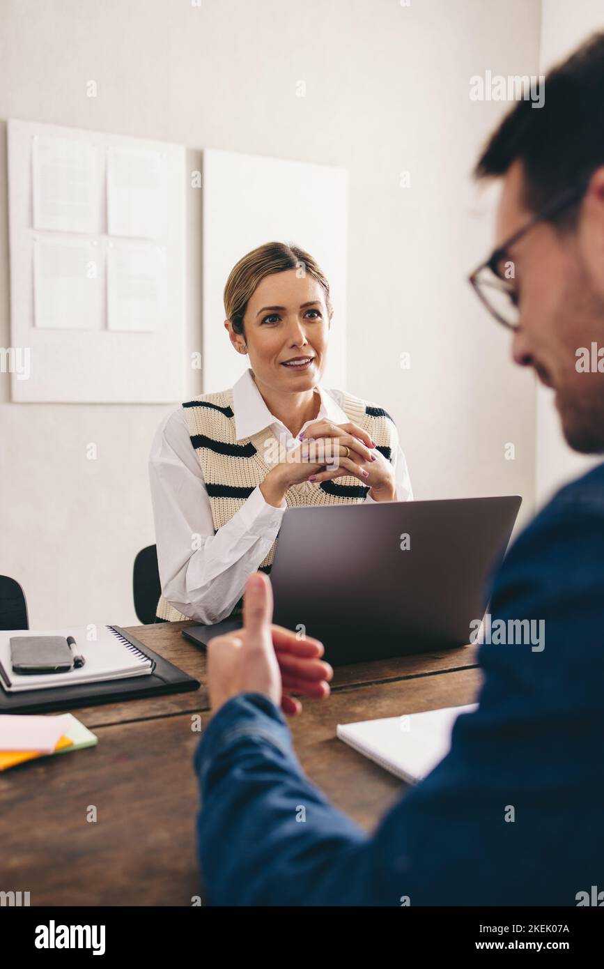businesswoman listening to a job applicant's answer during an interview ...
