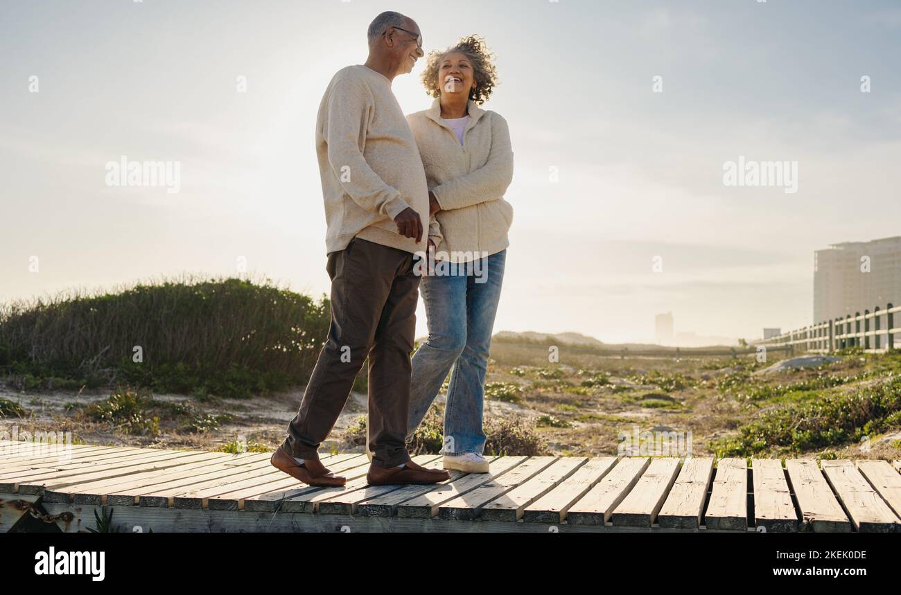 Carefree senior couple laughing and having a good time while walking ...
