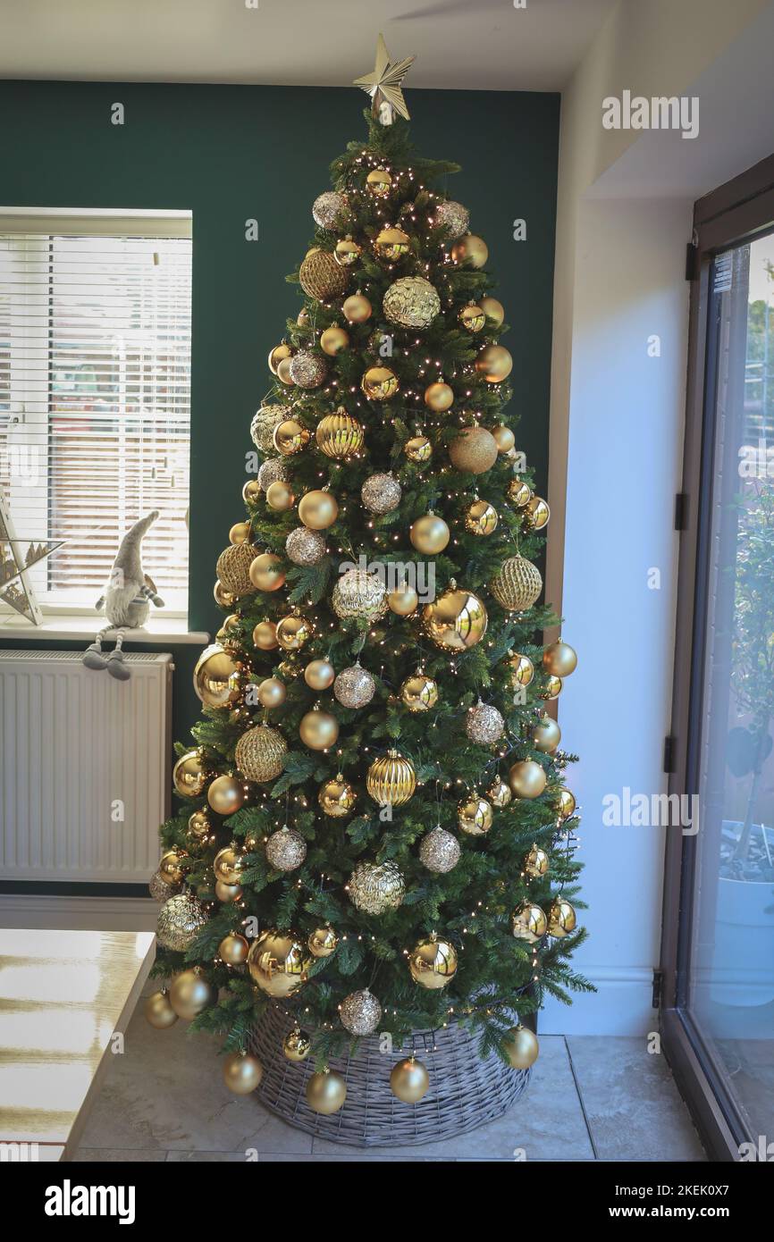 Slim 7ft Christmas Tree with Gold bauble decorations Stock Photo - Alamy