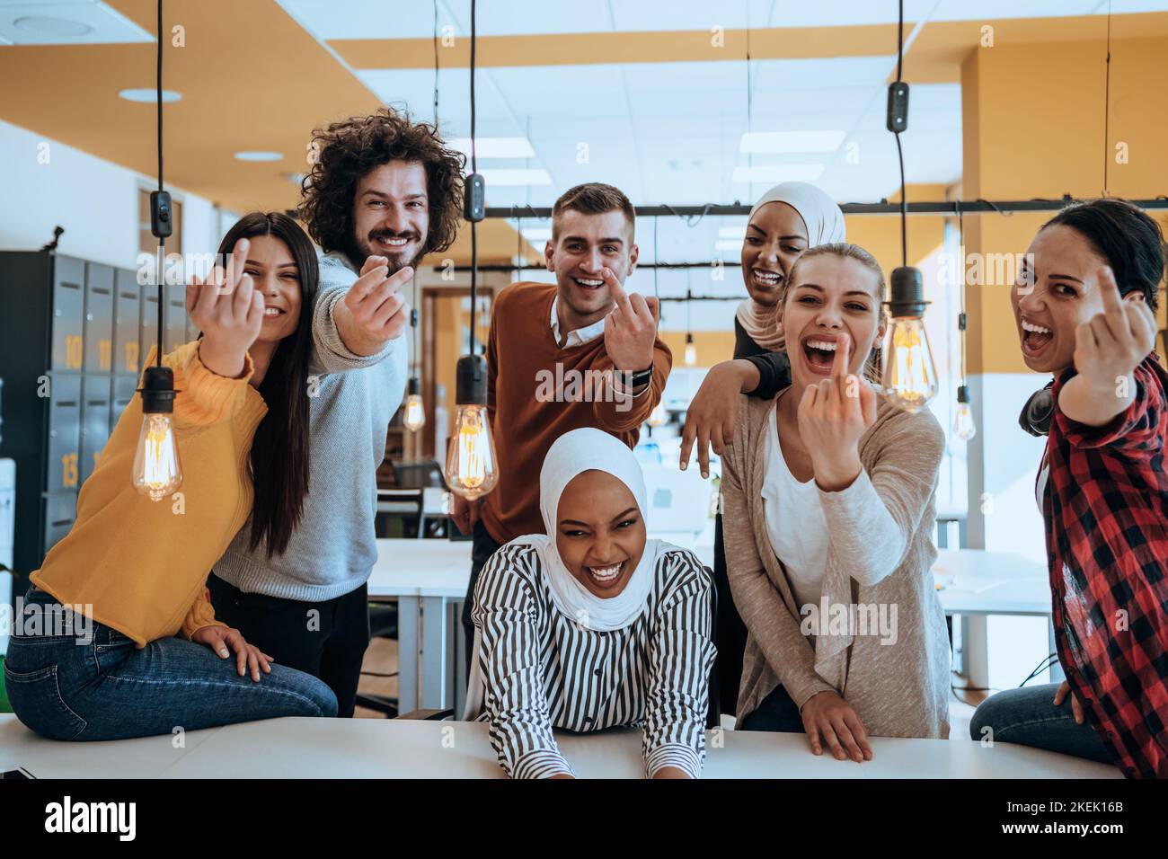 Group of diverse young man and girl in modern office showing middle ...