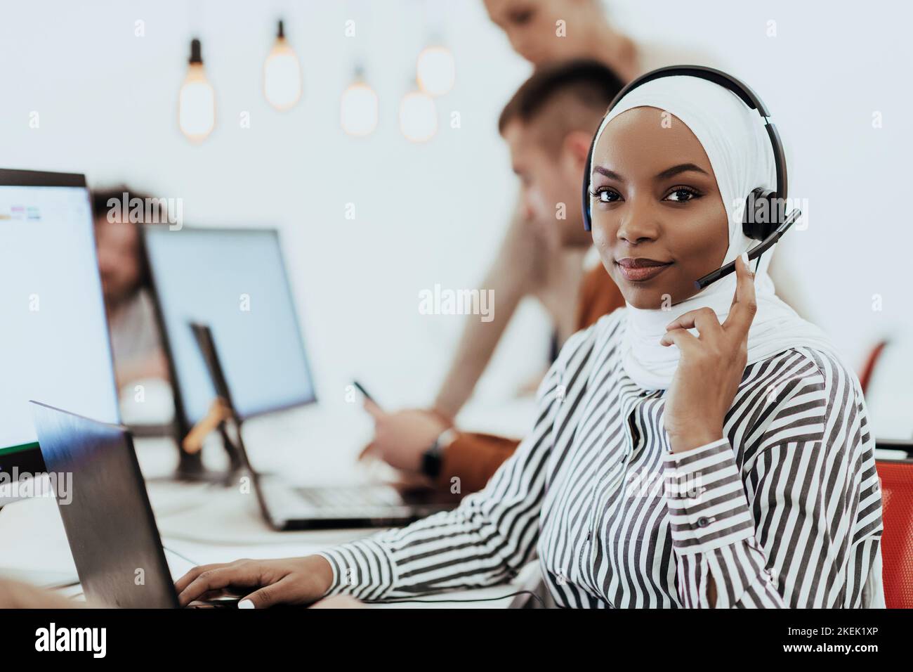 African American muslim woman with hijab and headset working as ...
