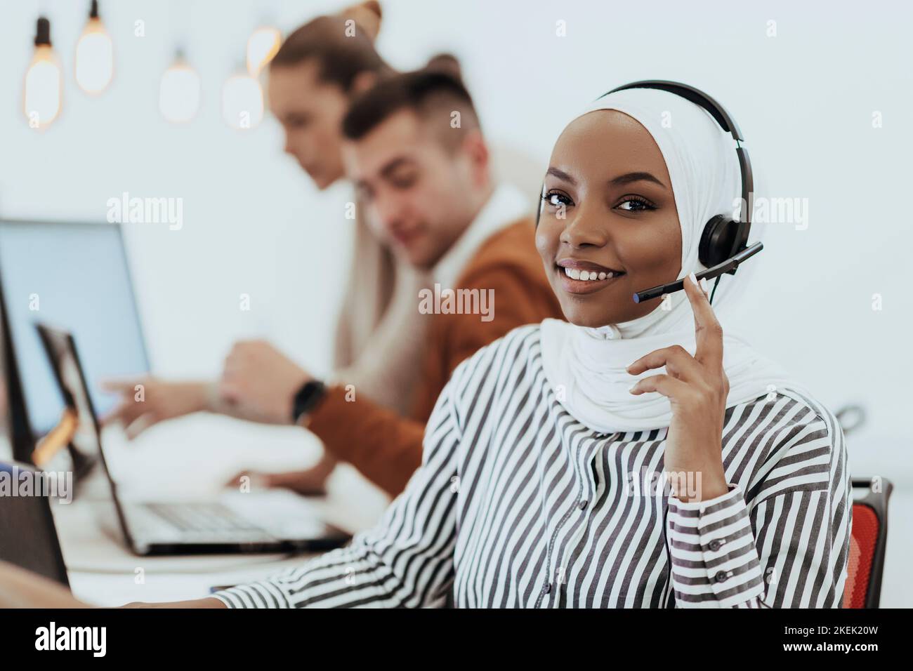 African American muslim woman with hijab and headset working as ...
