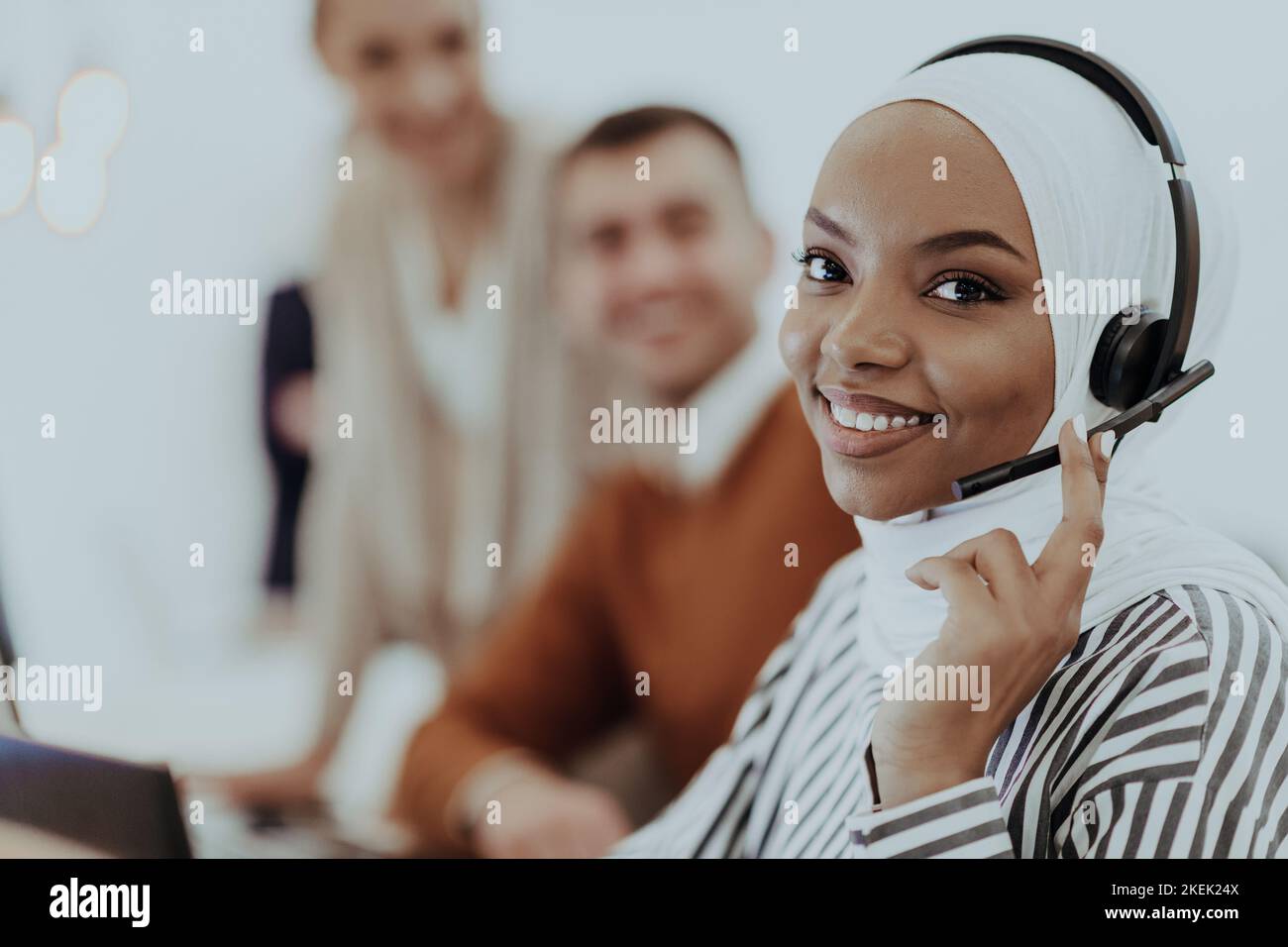 African American muslim woman with hijab and headset working as ...