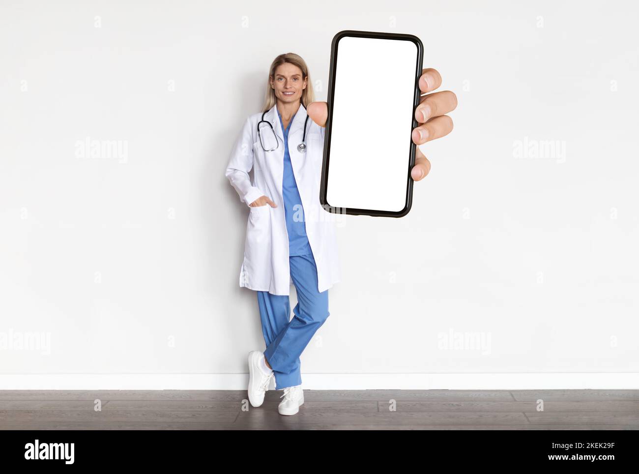 Medical Ad. Doctor Lady In Uniform Holding Big Blank Smartphone In Hand ...