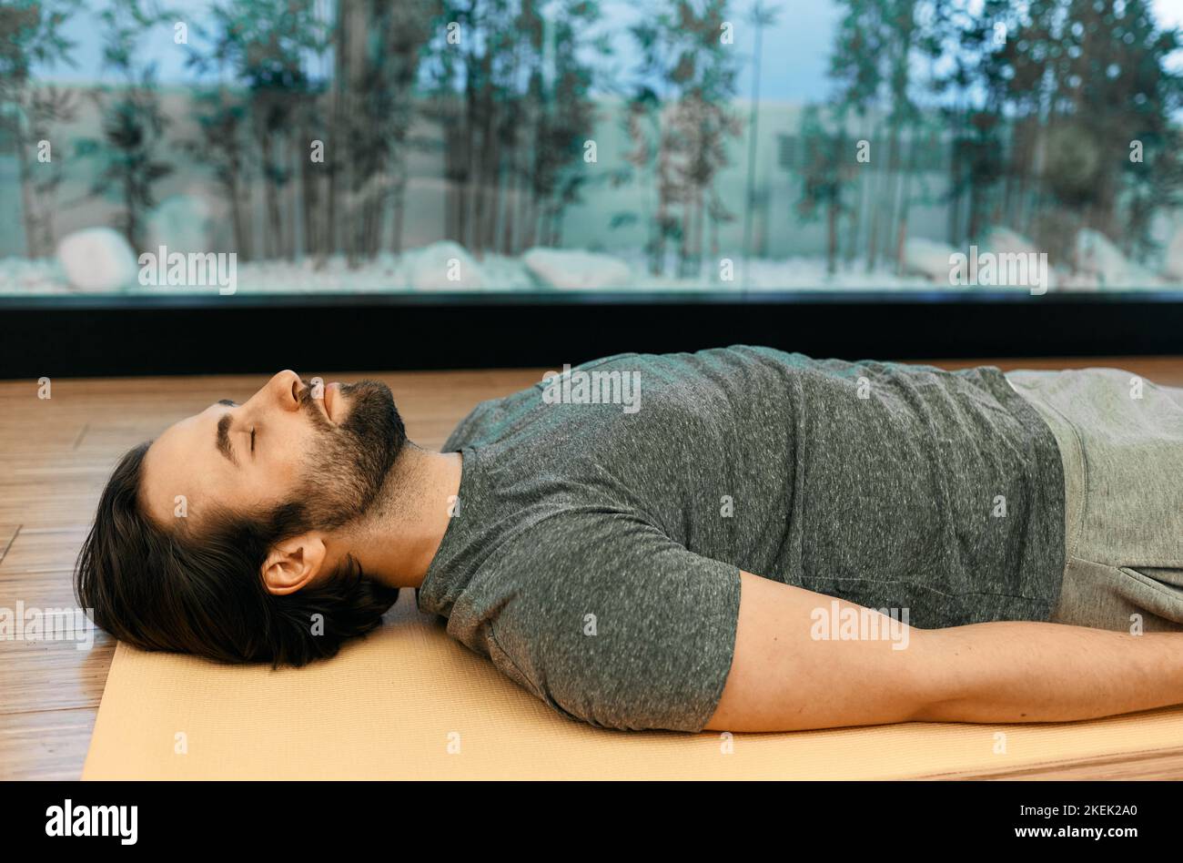 Savasana or corpse dead pose. Handsome man relaxes in motionless corpse ...