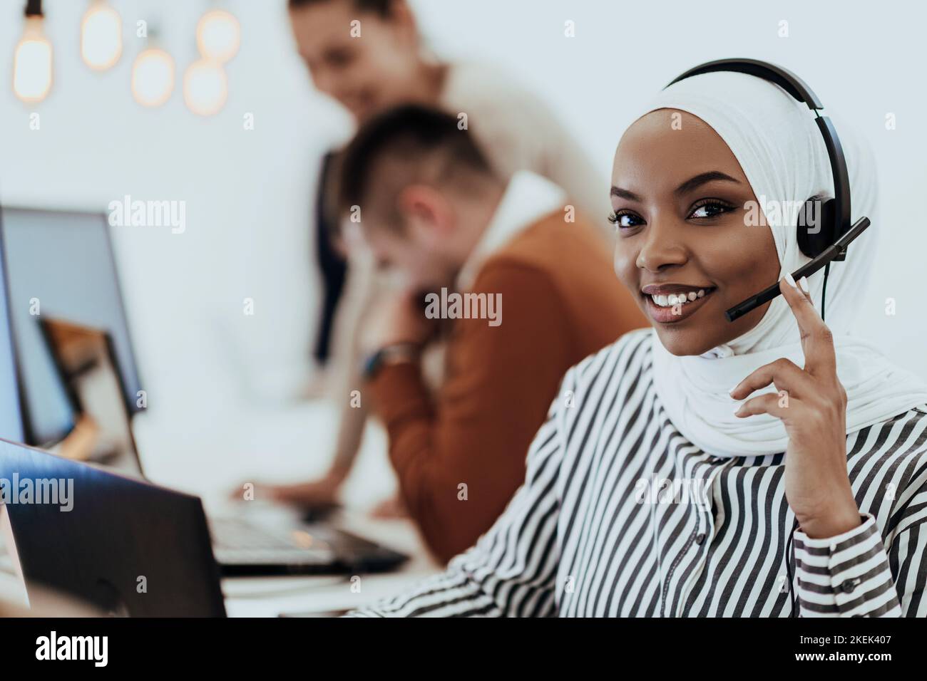 African American muslim woman with hijab and headset working as ...