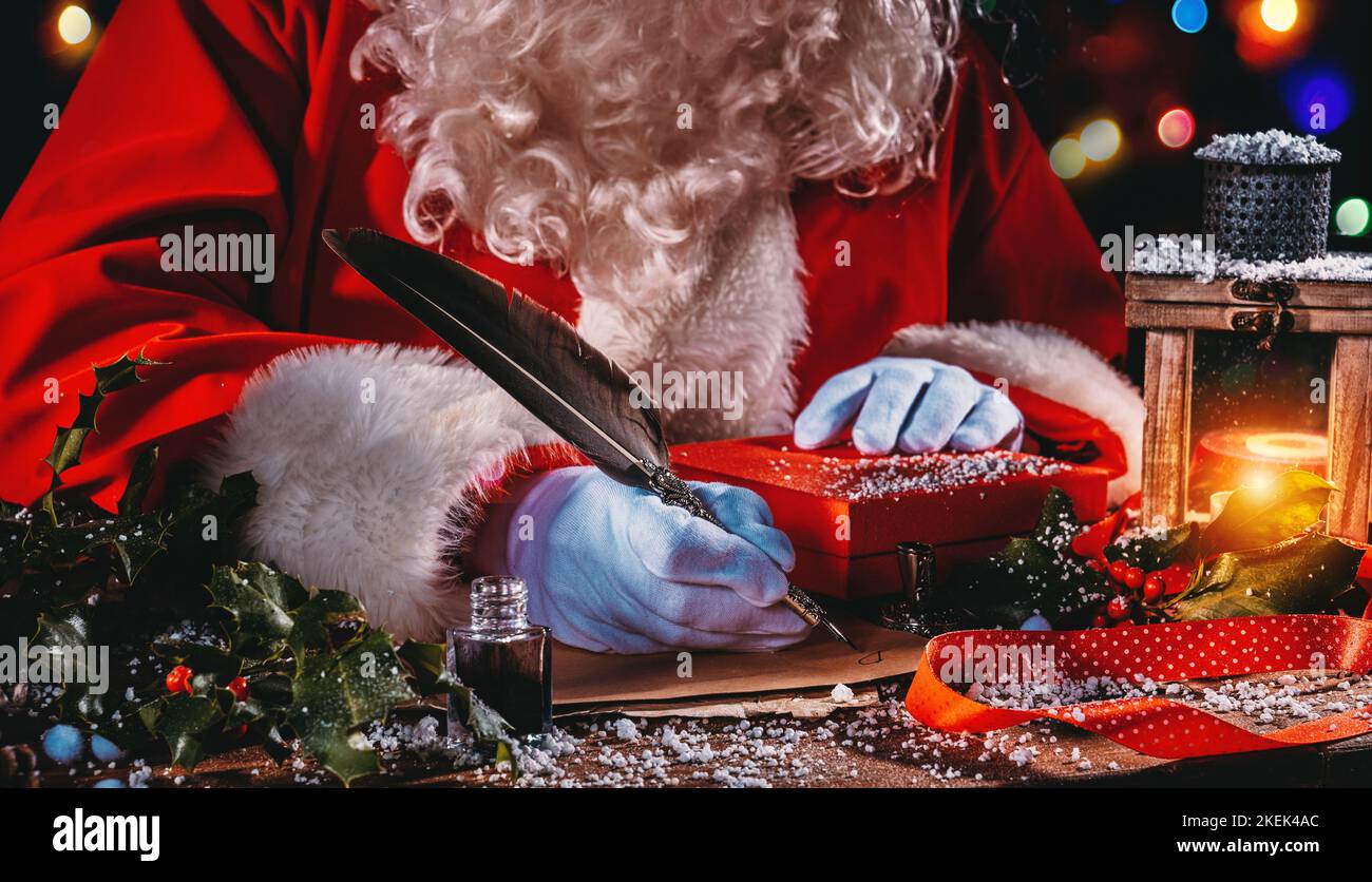 Santa claus writes a letter good wishes for Christmas gifts Stock Photo ...