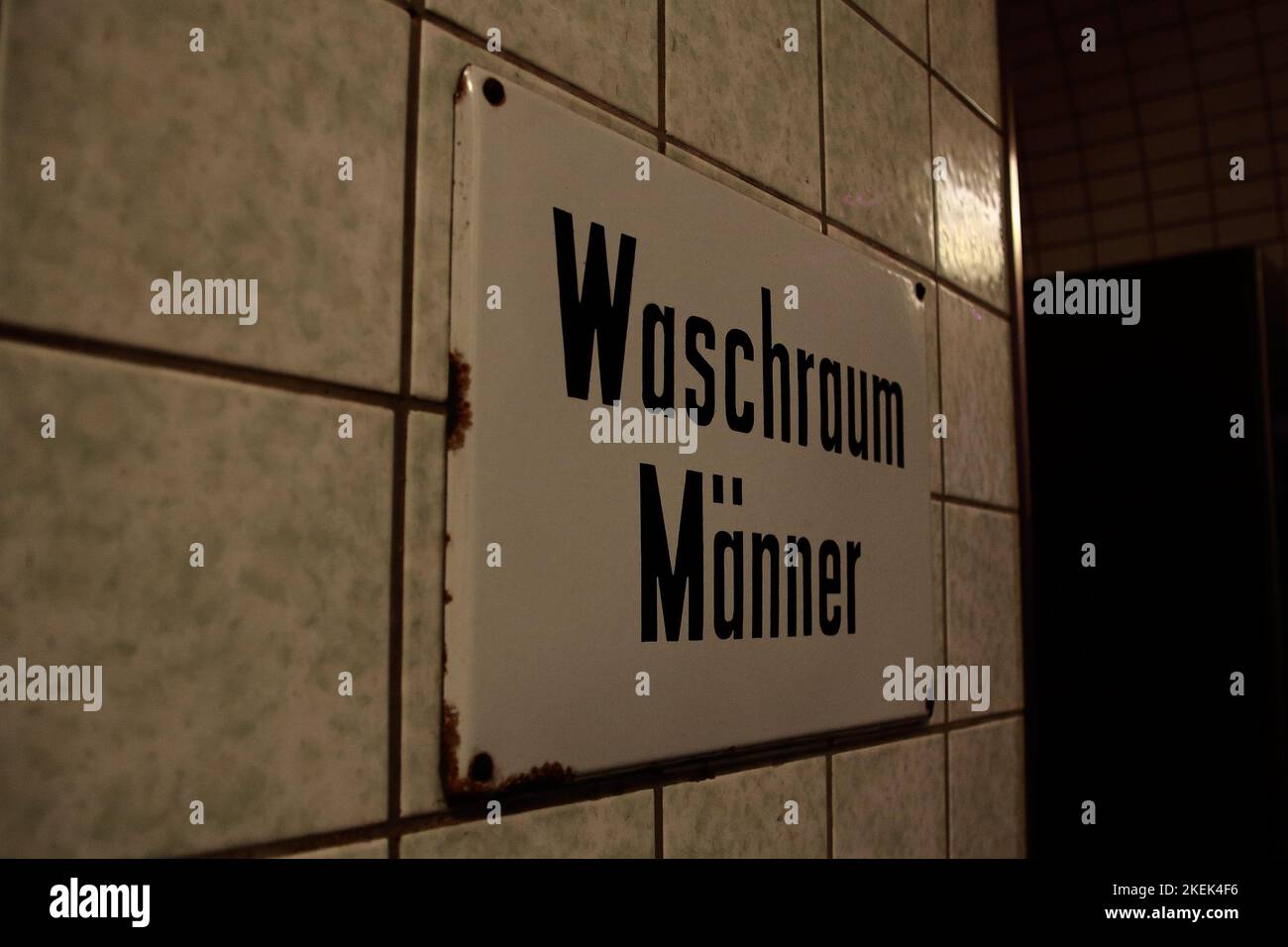 A washroom men sign on a tile-walled surface, closeup shot Stock Photo ...