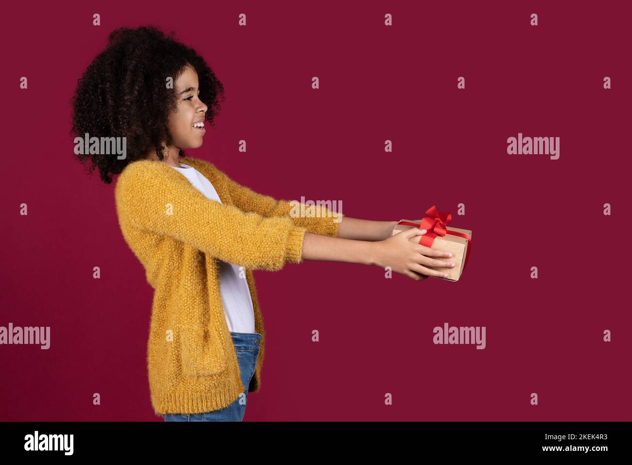 Cute Black Girl Giving Present Towards Copy Space Side View Stock
