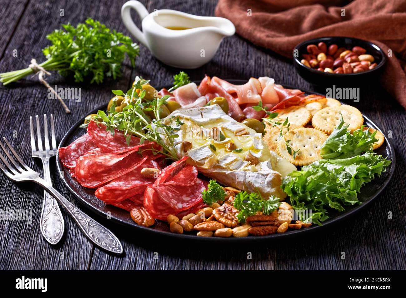 savory baked brie with crackers, spanish salchichon, salami sausages ...