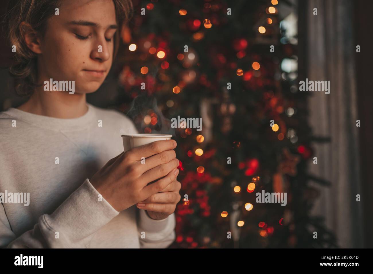 Young teen boy with long hair thoughtful look sad eyes negative mood ...