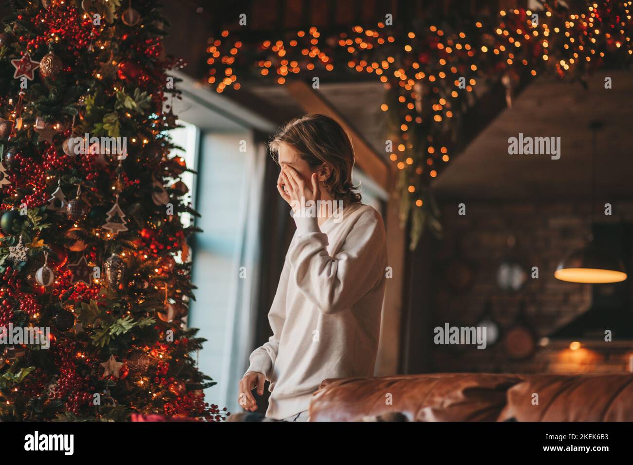 Young teen boy with long hair thoughtful look sad eyes negative mood ...