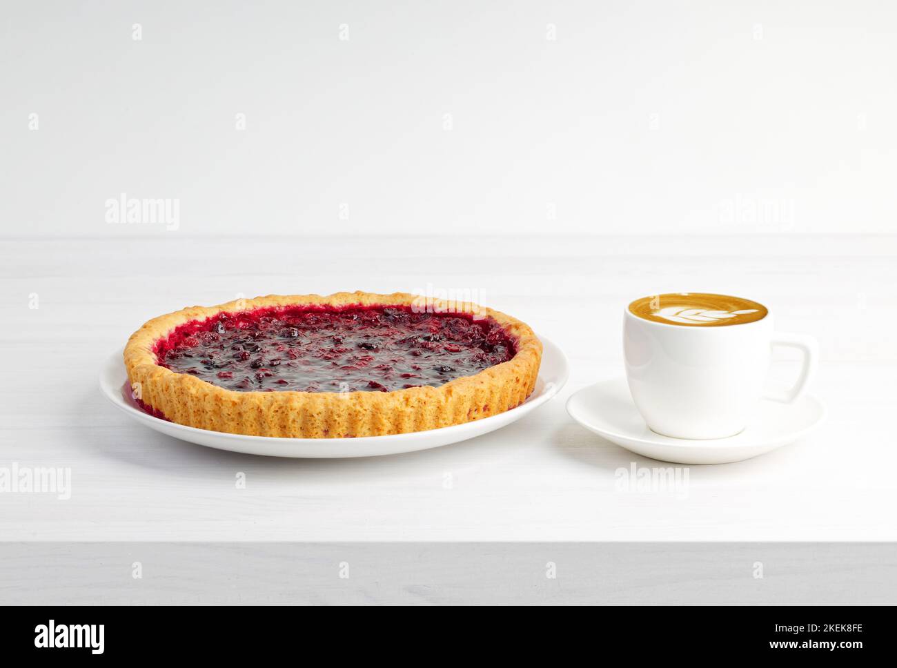 Homemade berry pie with cherry and cup of coffee cappuccino on white ...