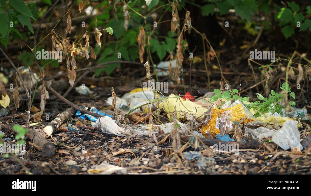 on ground, on side of road, lots of garbage is lying. scattered trash ...