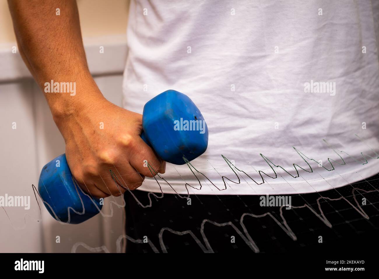 adult white male with a blue dumbbell in his hand with an ...