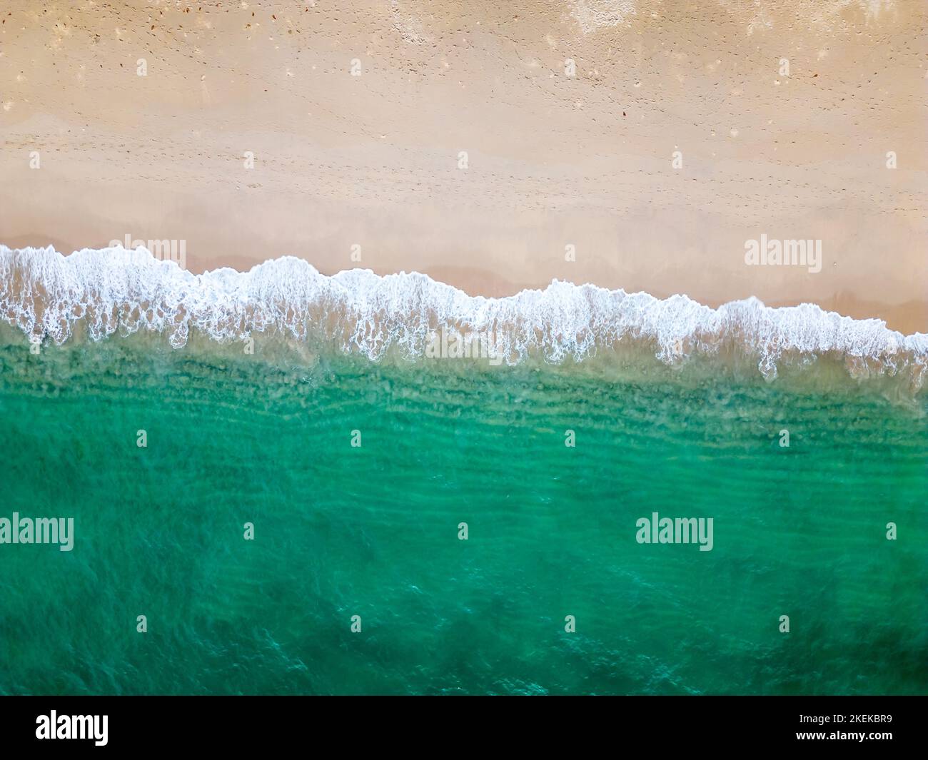 Aerial drone view (top down) to sea waves and white sand. Turquoise ...
