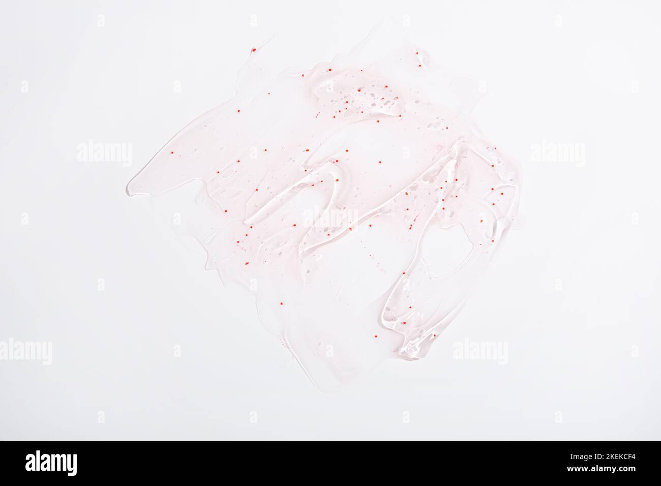 Top view of facial gel with red exfoliating particles on light surface ...