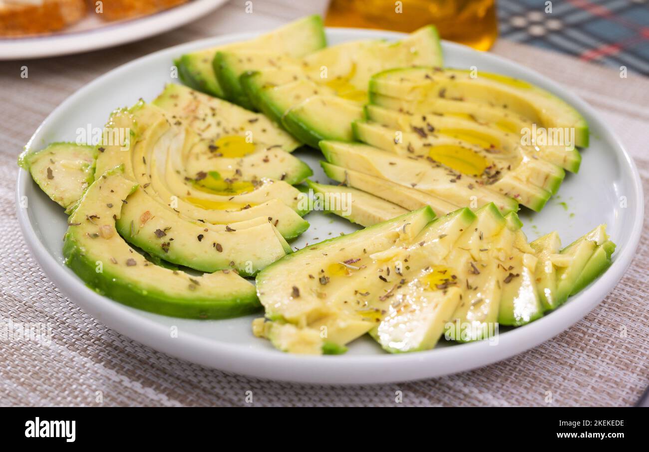 ripe avocado pulp cut into pieces sprinkled with lemon juice on a plate ...