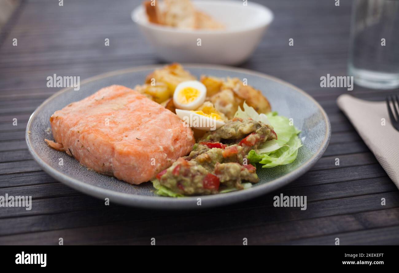 steamed salmon fillet with potato wedges, guacamole homemade and quail ...