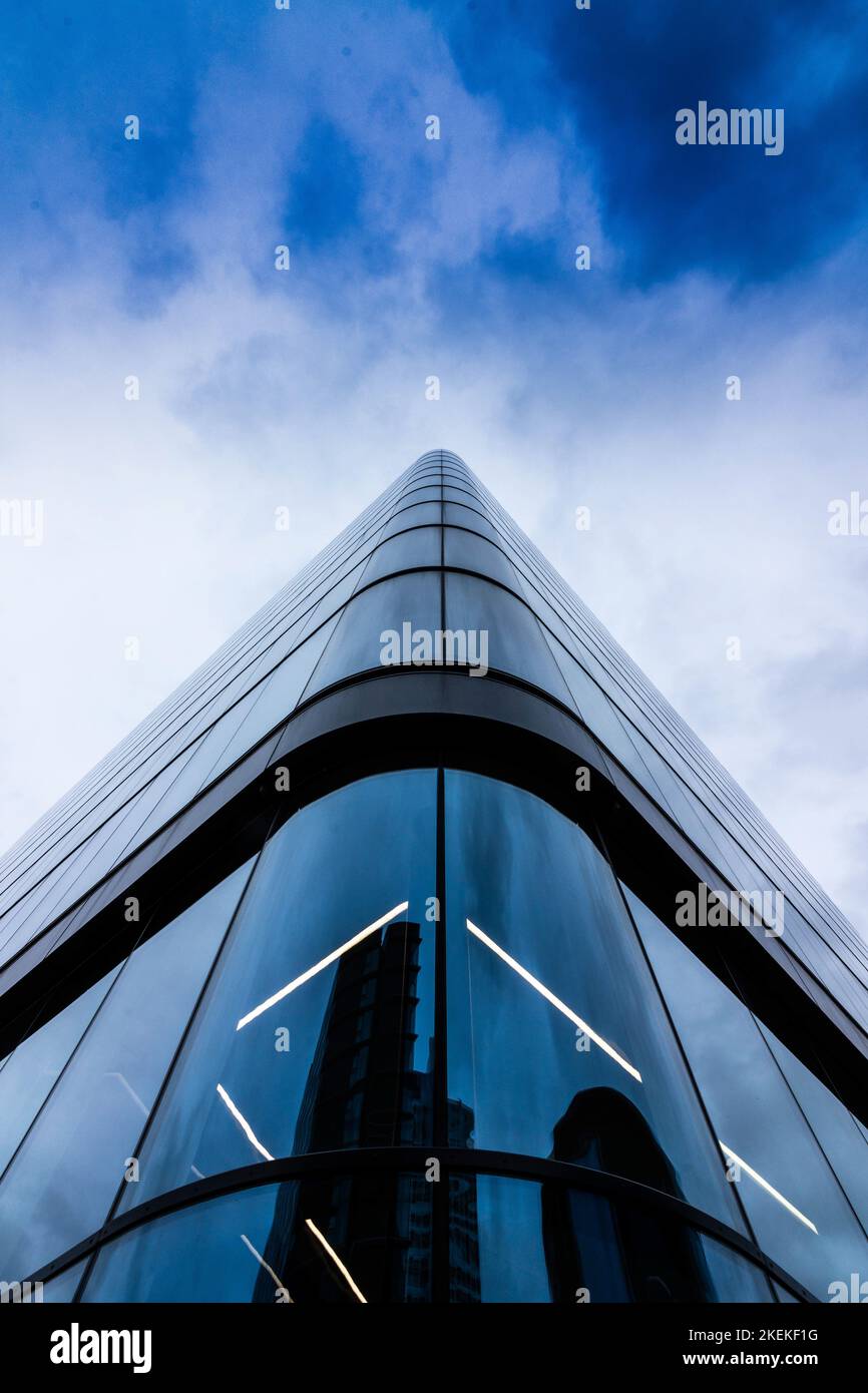 A low angle of a modern glass-walled building in Manchester, England ...