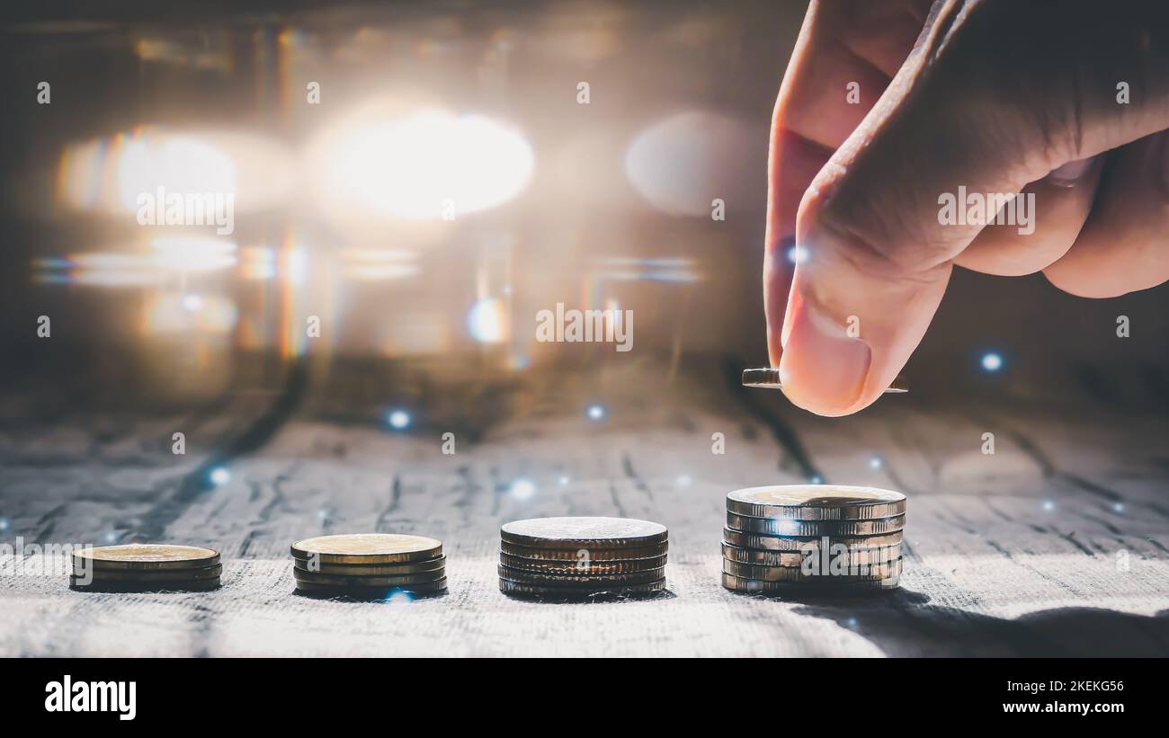 Man hand stacked coins with money saving concept and profit graph ...