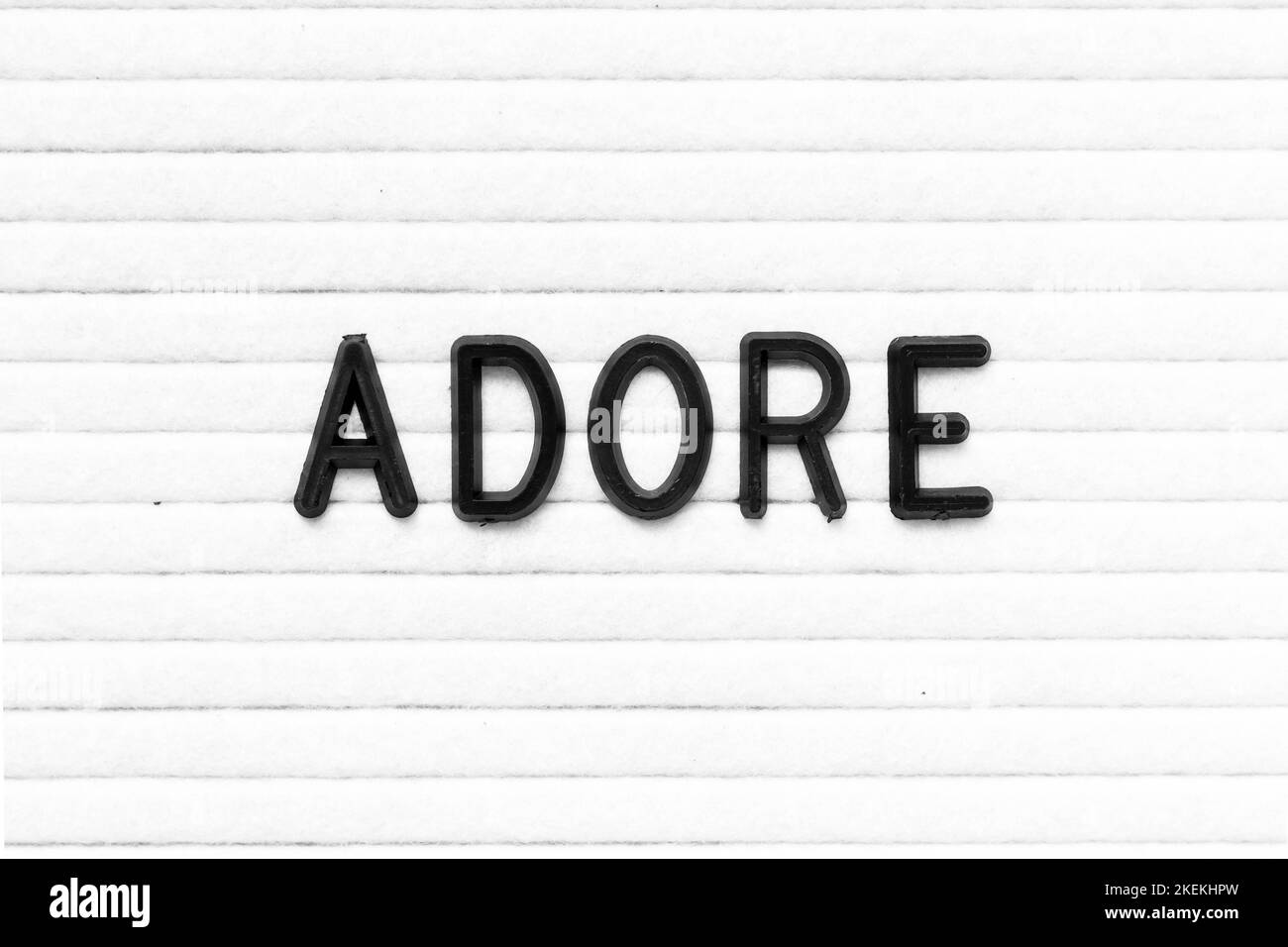 Black color letter in word adore on white felt board background Stock ...