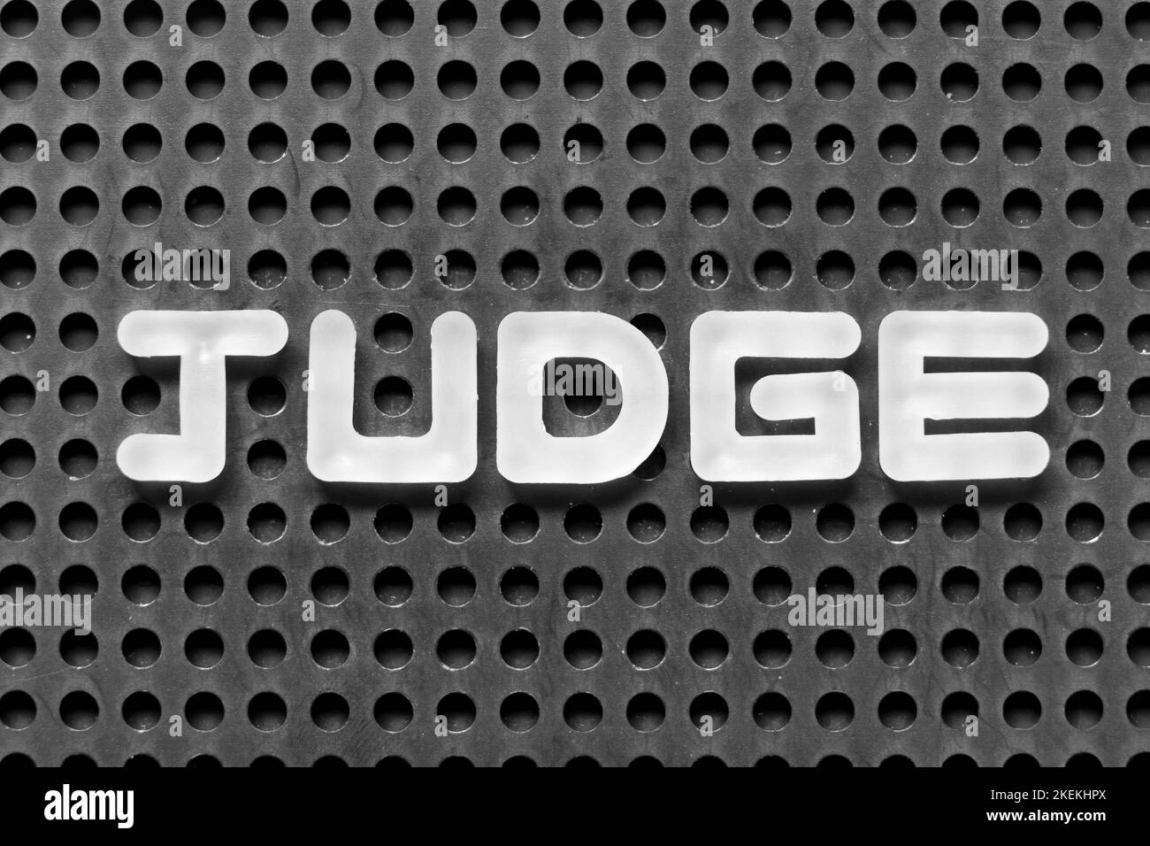 White alphabet letter in word judge on black pegboard background Stock ...