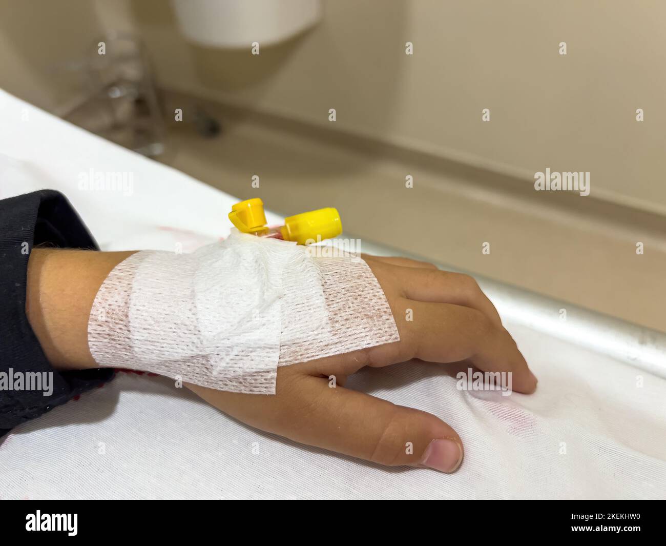 Vascular access on the hand of young sick girl at the hospital bed ...