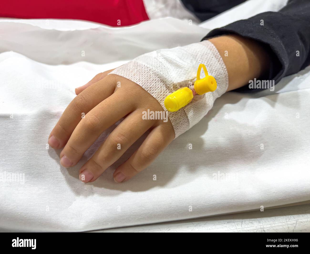 Vascular access on the hand of young sick girl at the hospital bed ...