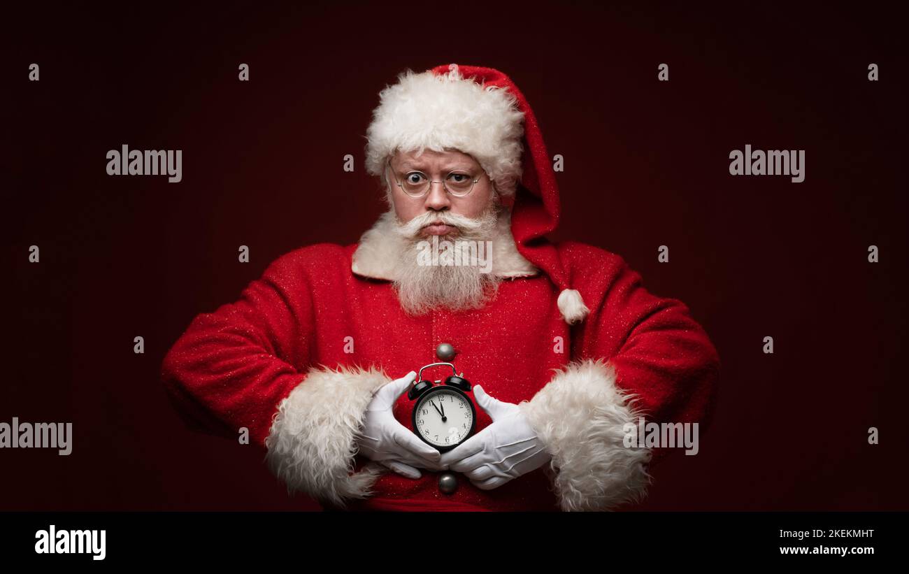 Santa claus holding alarm clock almost midnight Stock Photo - Alamy
