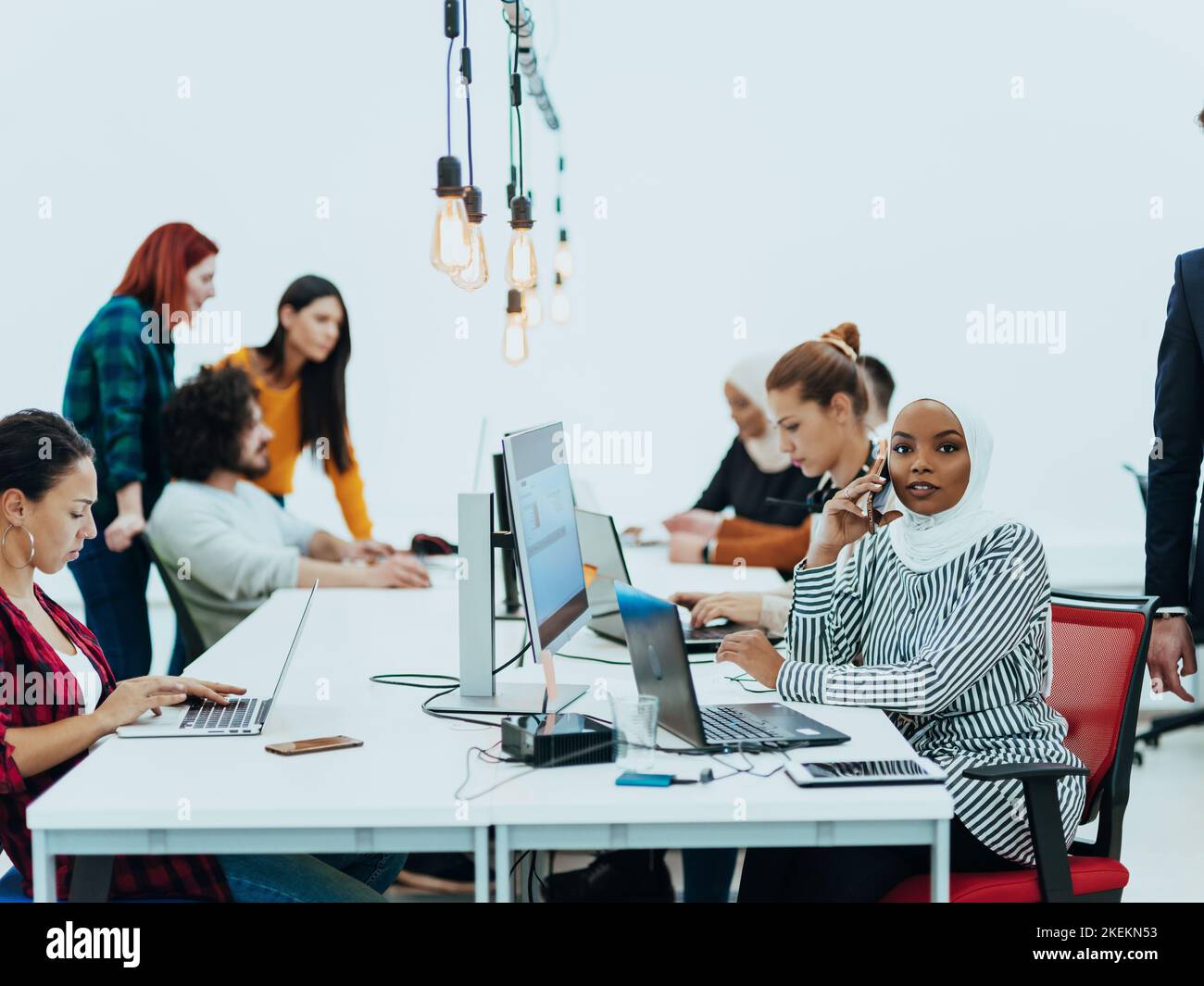 Group of multi-ethnic colleagues working on desktop computers, laptop ...