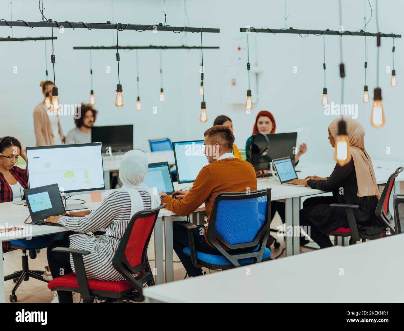 Group of multi-ethnic colleagues working on desktop computers, laptop ...