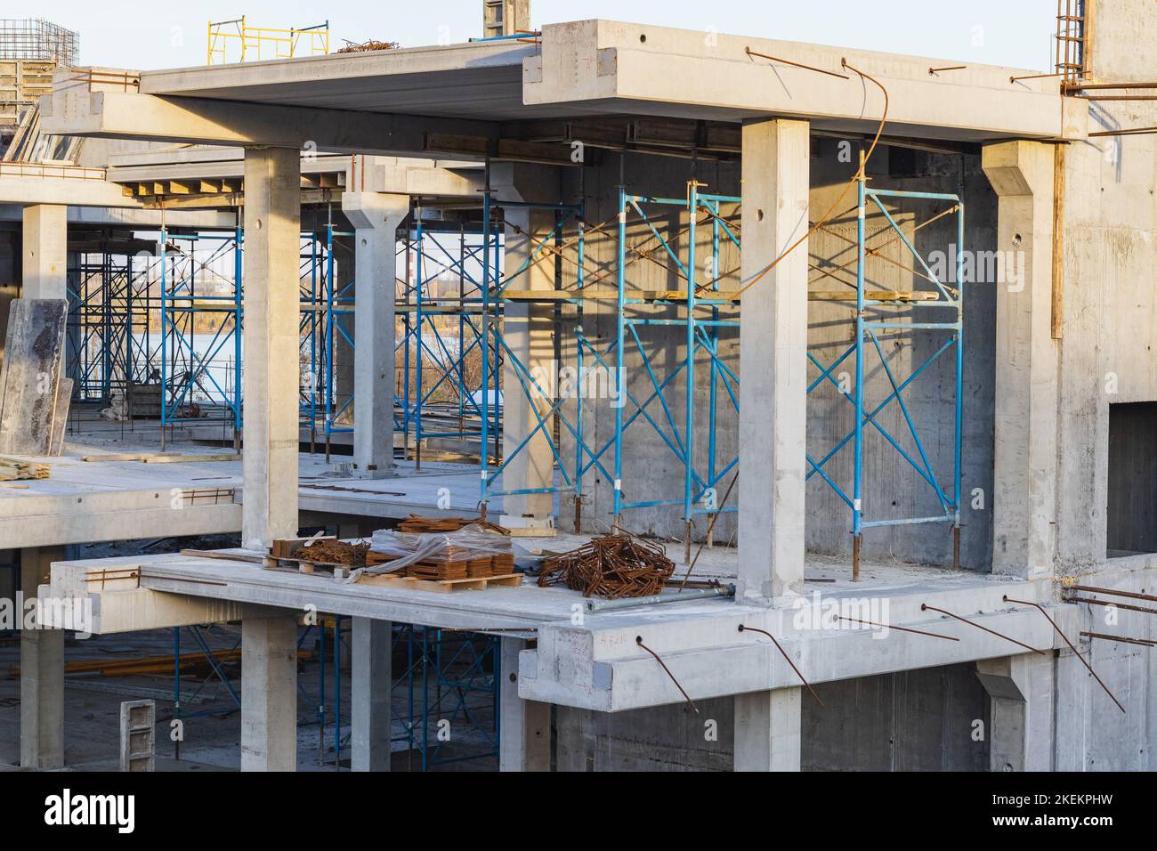 Crane and building under construction against blue sky on lake bank ...