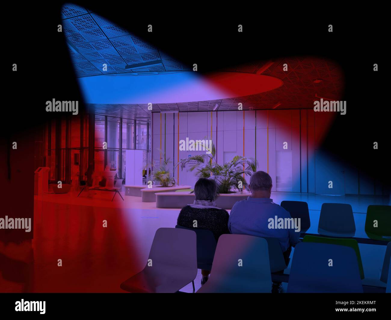 Rear view of couple waiting inside modern large new hospital room hall ...