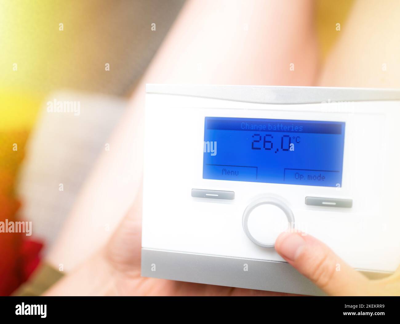 Close-up of woman turning dial wheel of a connected thermostat with ...