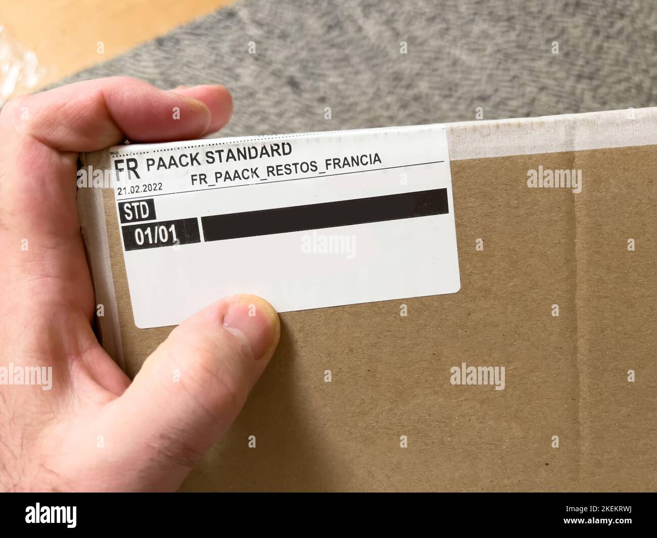 Paris, France - Feb 27, 2022: POV male hand holding package cardboard ...