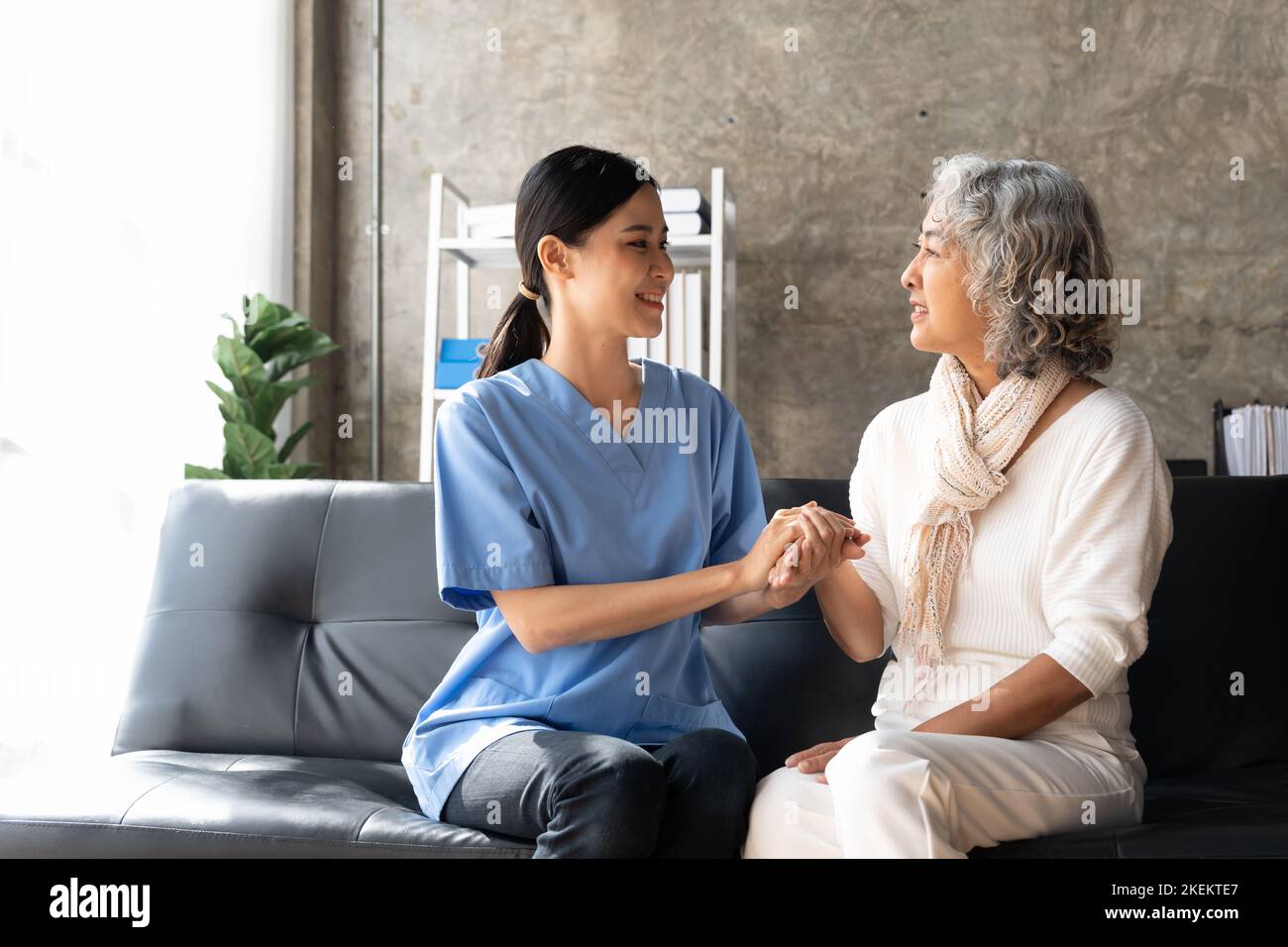 Happy patient is holding caregiver for a hand while spending time ...