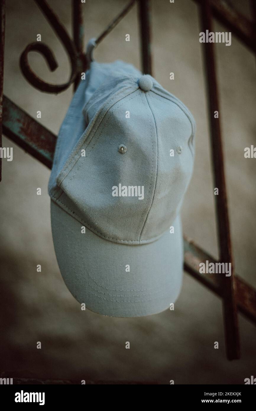 A cap hanging on the steel fence Stock Photo - Alamy