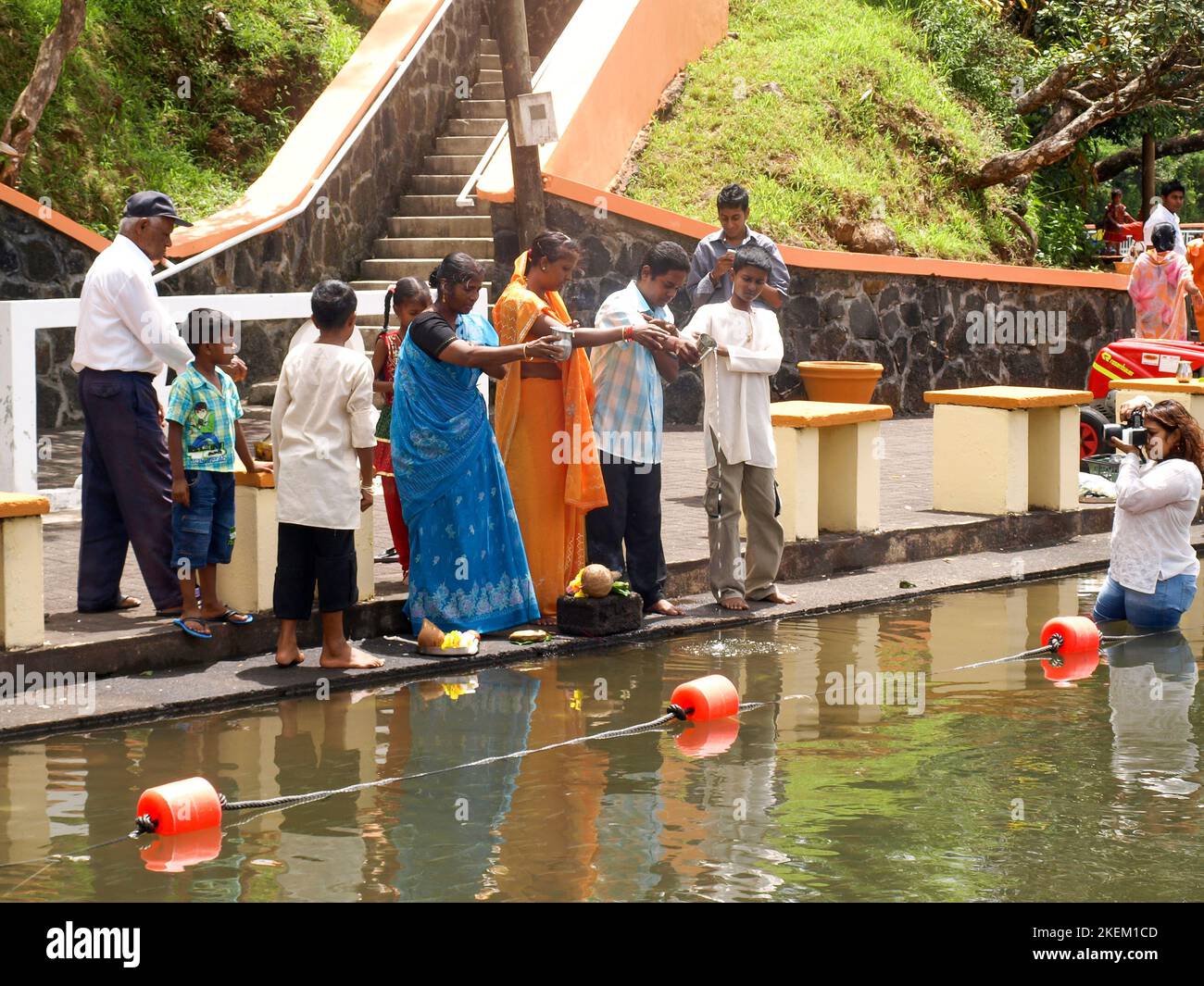 GRAND BASSIN, MAURITIUS - FEBRUARY 24, 2011: Family offers food as a ...