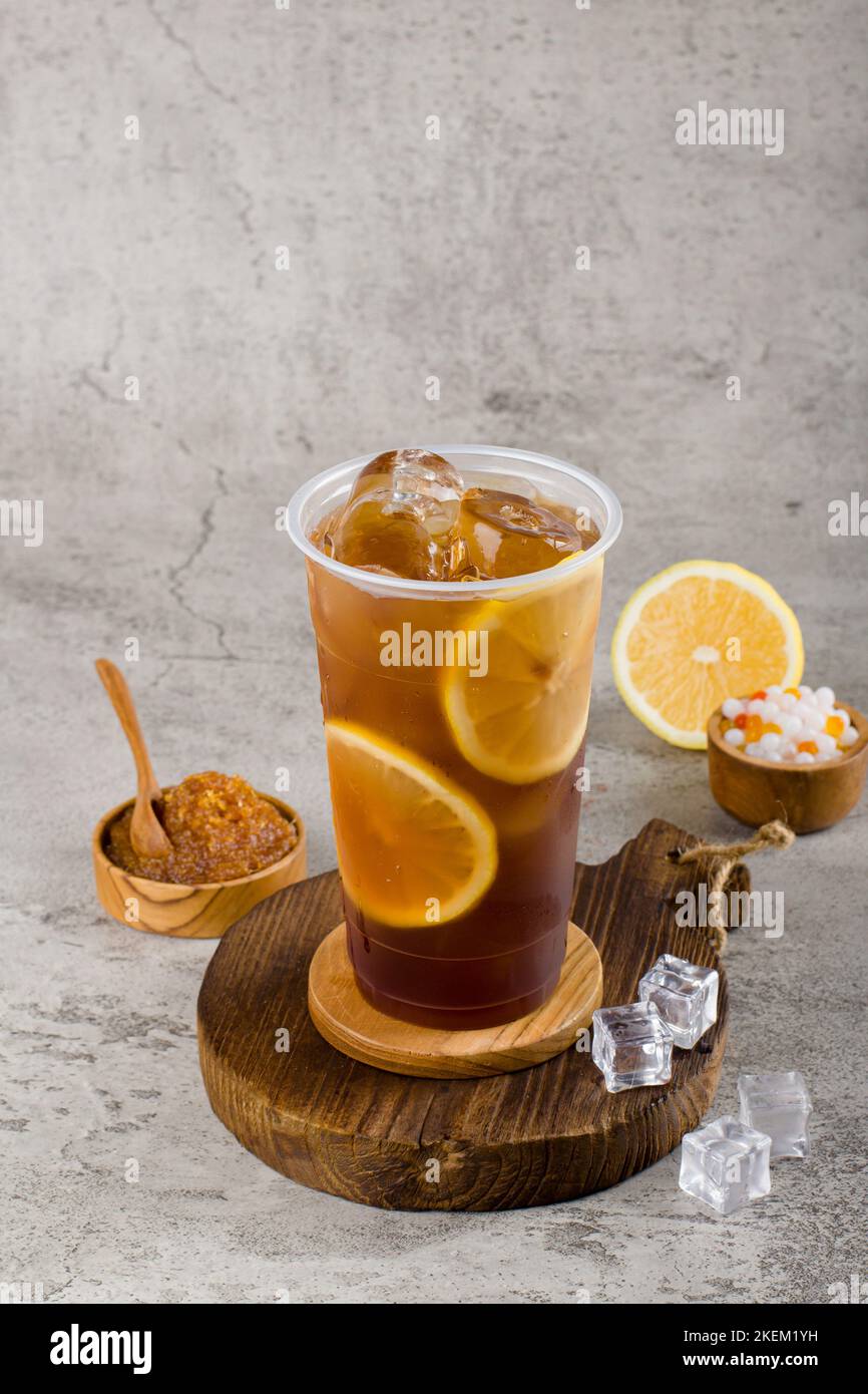 sweet lemonade tea in plastic cup with iced on texture background ...