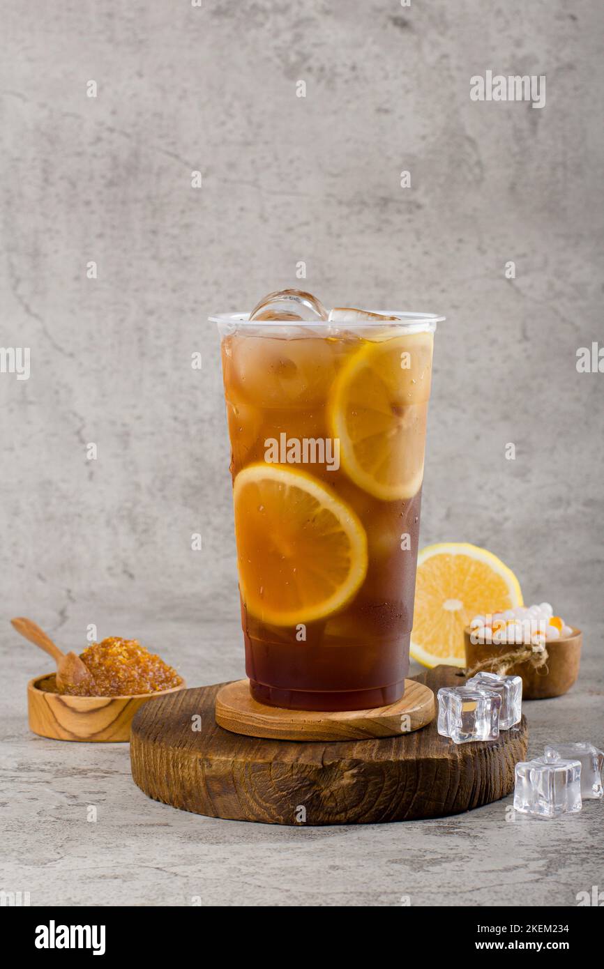 sweet lemonade tea in plastic cup with iced on texture background ...