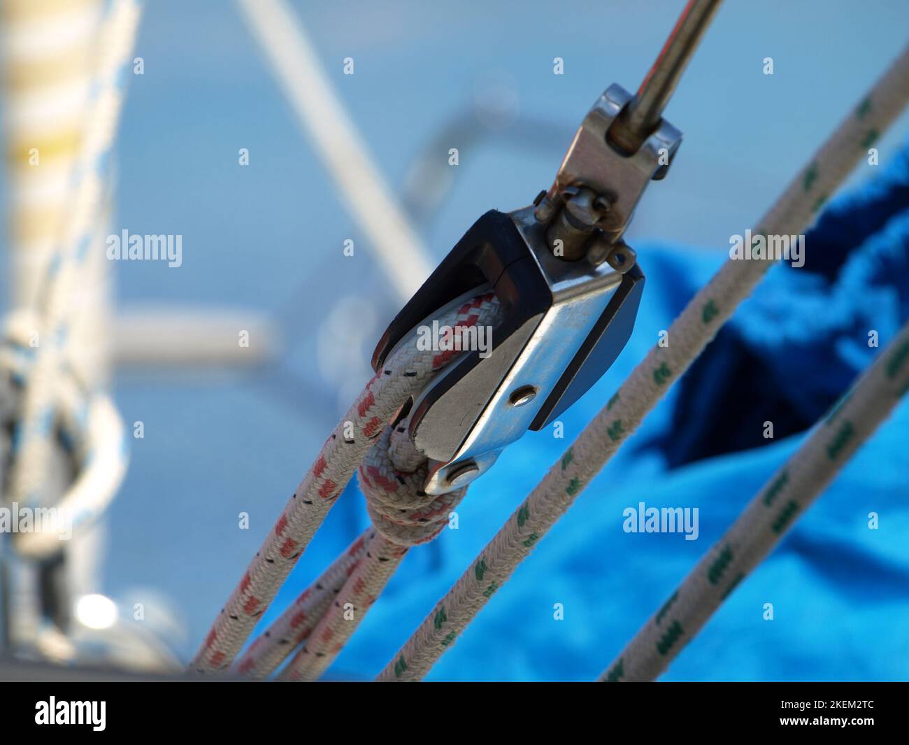 Pulley on the main boom ofa a sailing yacht in front of a clear blue ...
