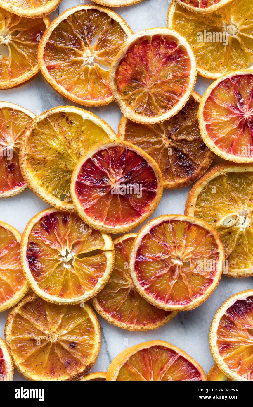 Top down view of several dried spiced orange slices against a light ...