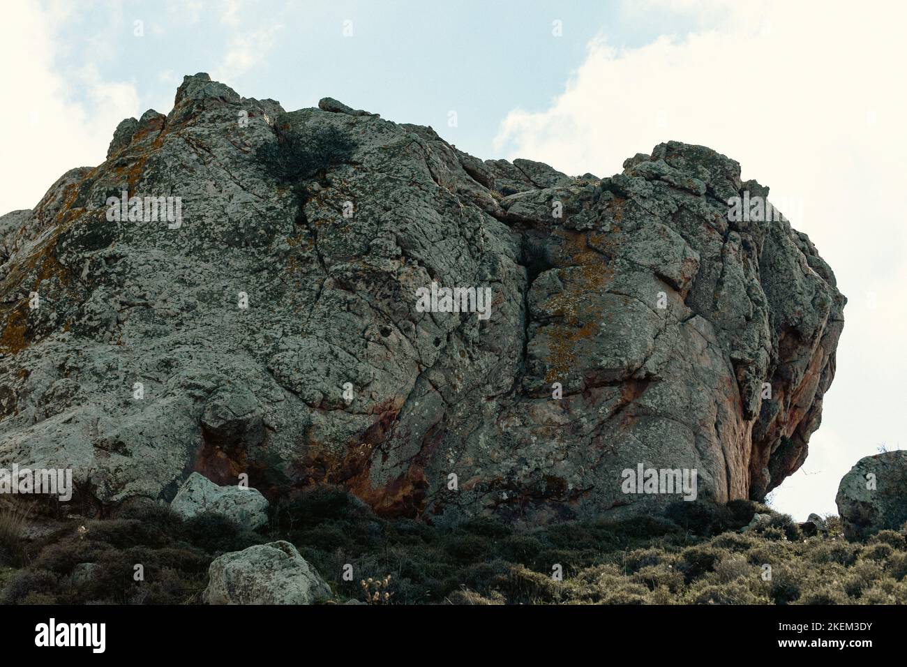 A low angle of a gray and orange cliff on the grassy ground during the ...