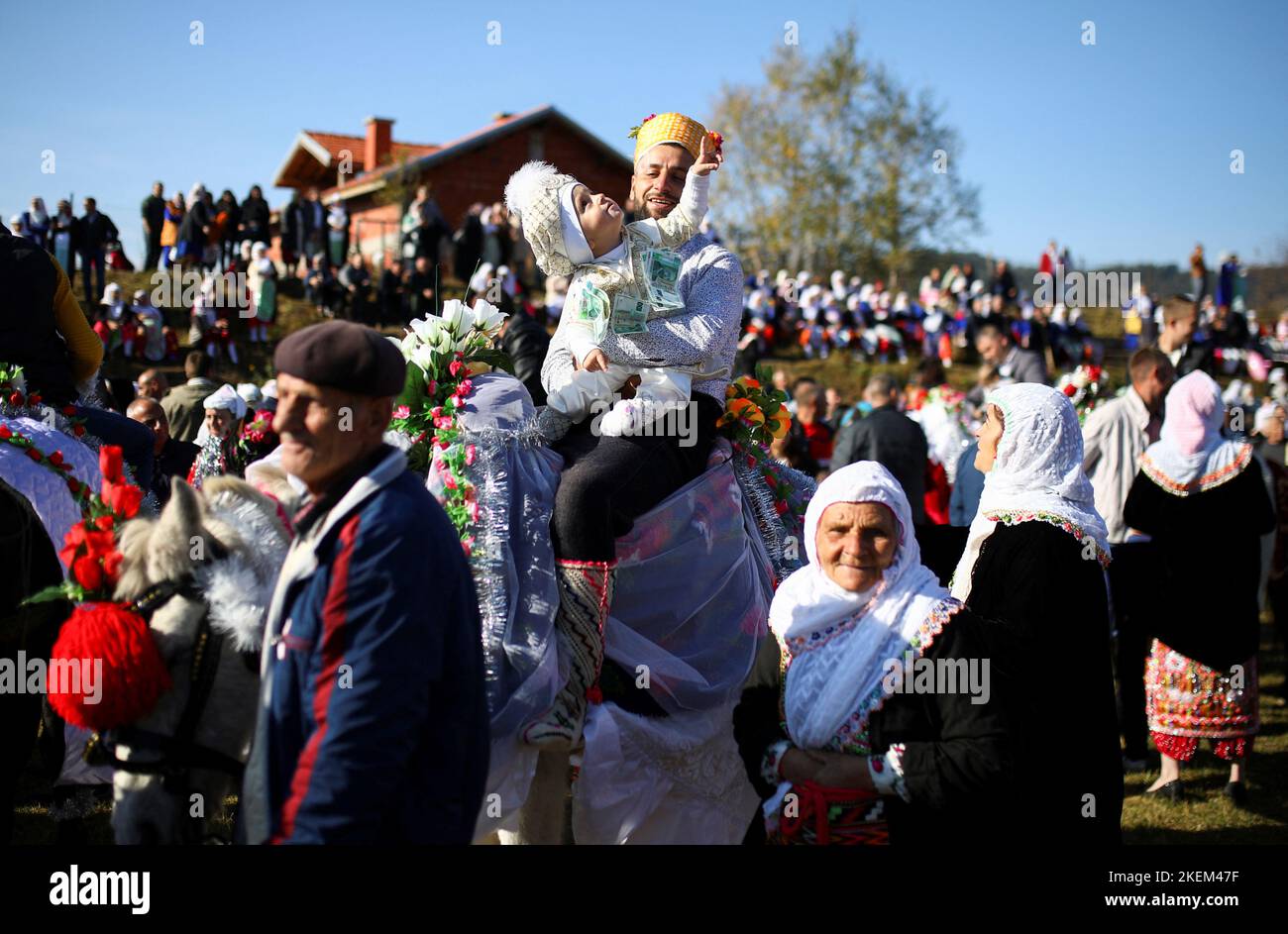 A Bulgarian Muslim man carries his son on a horse as they attend a ...