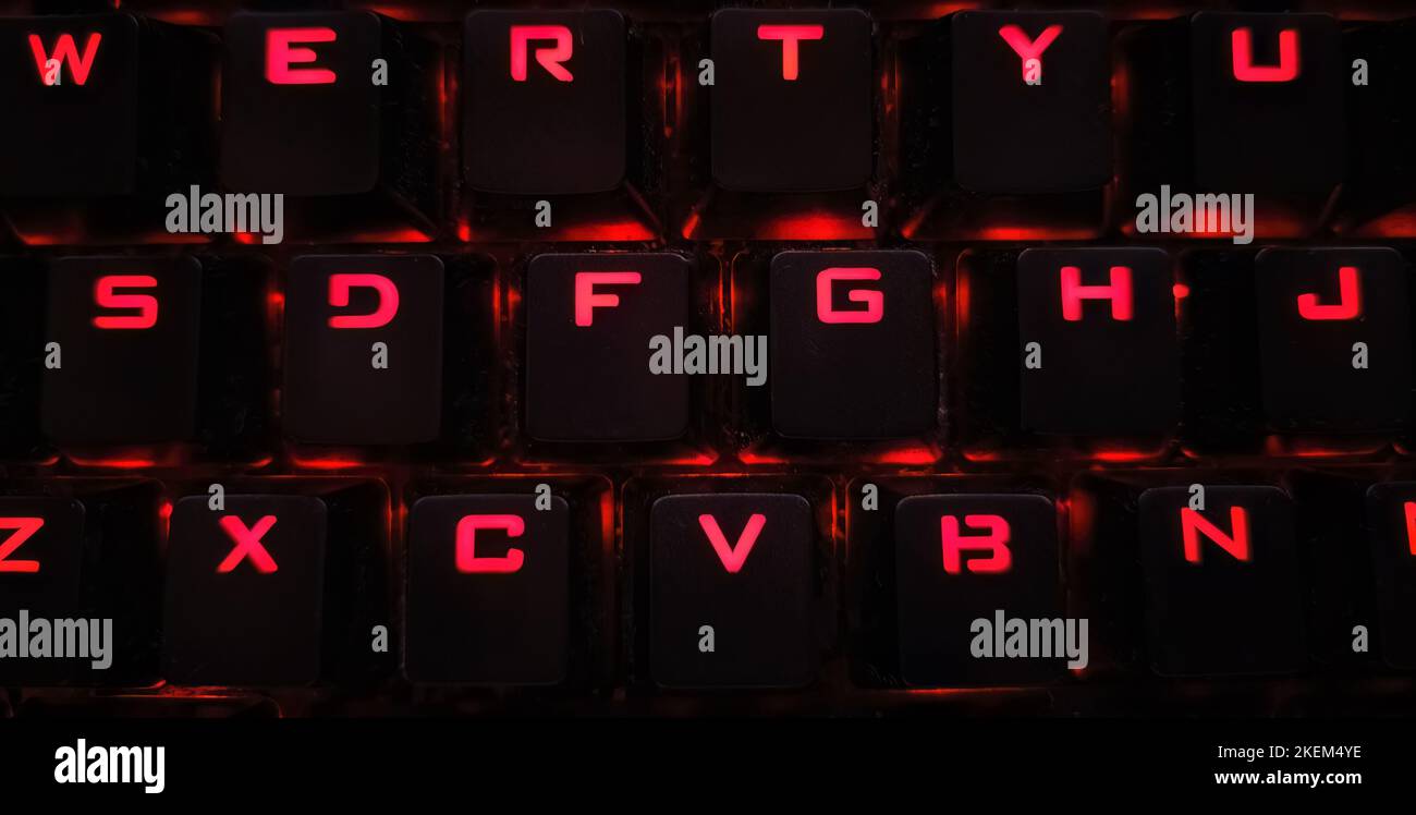Backlit keyboard close up. Black keys with illuminated characters ...